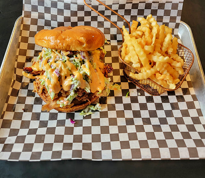 Pulled Pork Sandwich with Fries: The perfect partnership &ndash; that legendary pulled pork sandwich alongside golden fries waiting to soak up every drop of sauce.