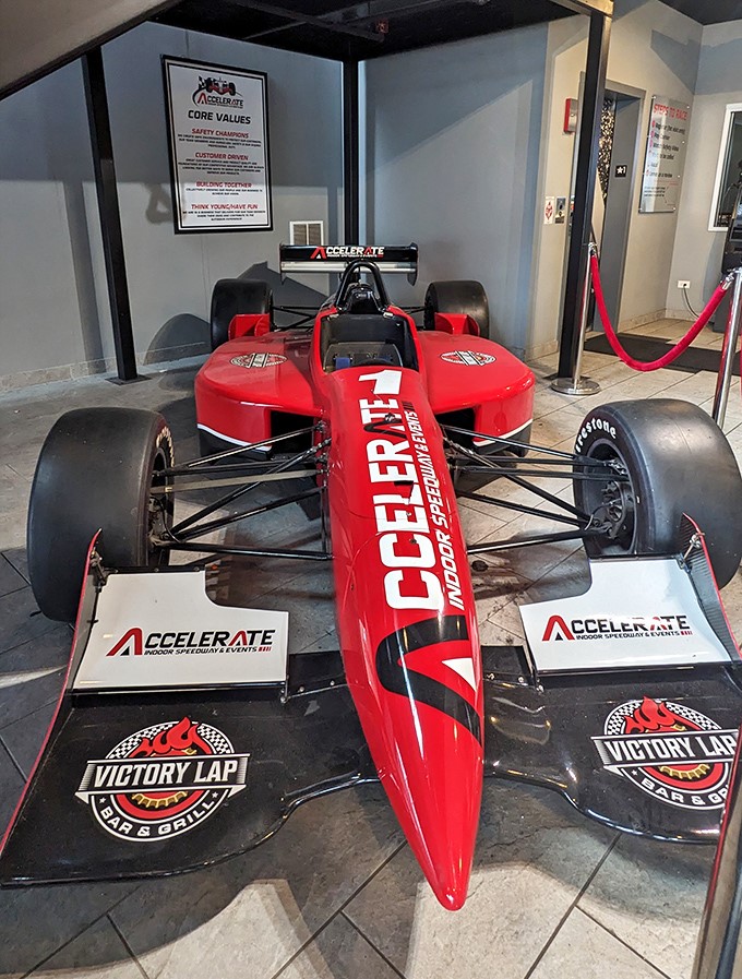 This professional-grade race car display showcases the connection between the go-kart experience and the world of professional motorsports that inspires it.