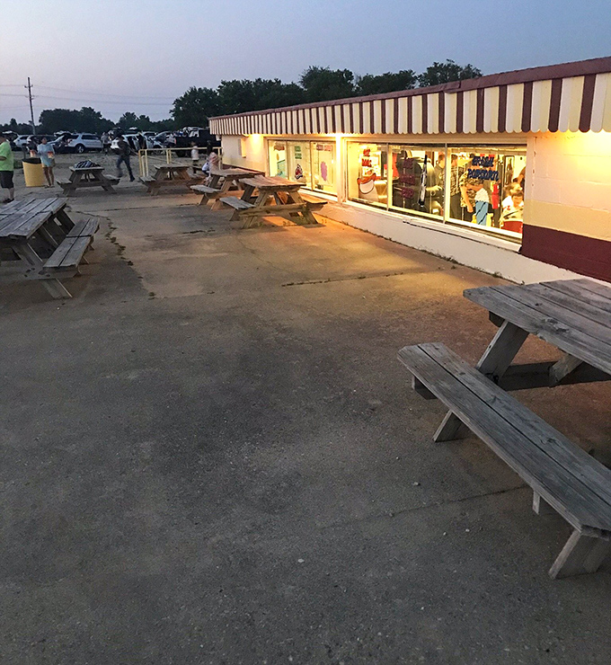 As dusk approaches, the picnic tables outside the concession stand become community gathering spots for pre-movie socializing.