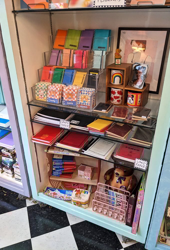 Rainbow-ordered notebooks and planners stand at attention, ready to organize your life with more style than your first Trapper Keeper ever did.