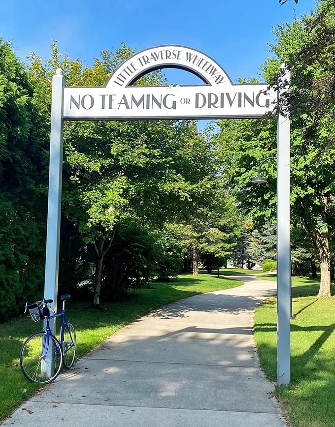 The Little Traverse Wheelway entrance stands like a portal to another world, where cars are forbidden and calories disappear without guilt.