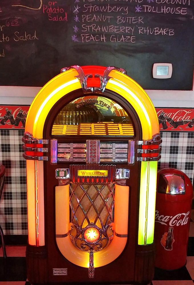 The Wurlitzer jukebox stands sentinel in the corner, ready to transport you back to when music came with a side of mechanical magic.