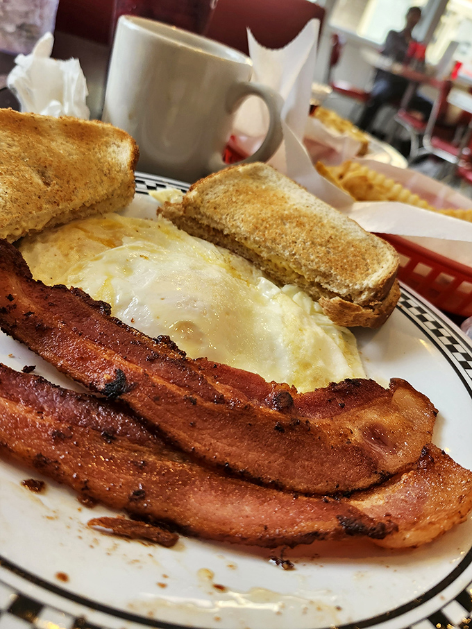 Breakfast perfection: crispy bacon that snaps just right, eggs cooked exactly how you asked, and toast that's been buttered with what can only be described as enthusiasm.