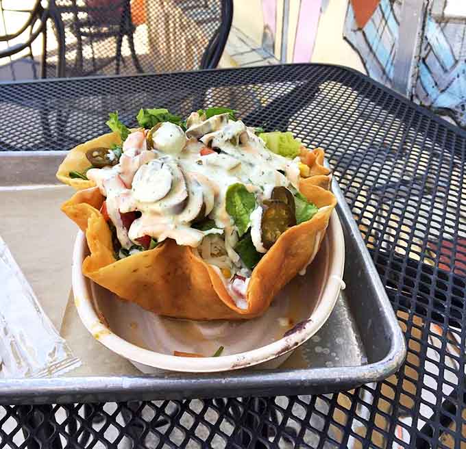 This isn't your sad desk salad! Fresh ingredients cascade over crisp lettuce in a tortilla bowl that somehow defies the laws of sogginess.