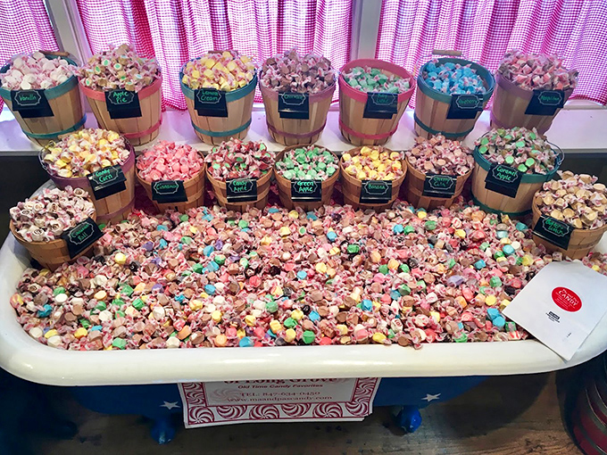 Wooden barrels overflow with colorful taffy and popcorn varieties, creating a rustic rainbow of sweet and savory options.