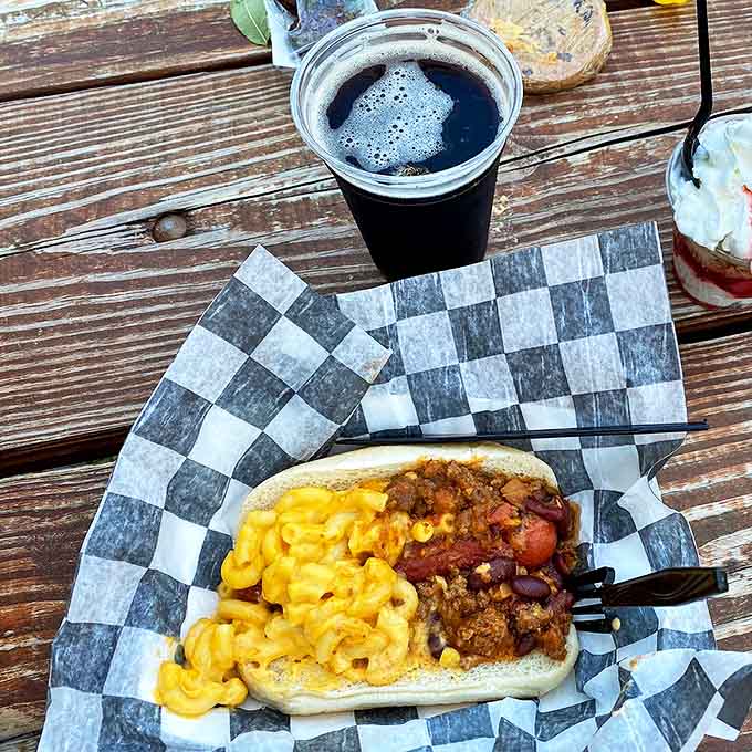 This magnificent creation marries two comfort food classics &ndash; a juicy hot dog nestled under a blanket of chili and mac & cheese.