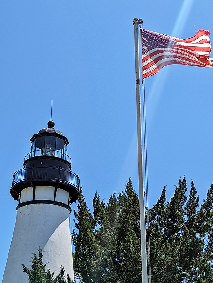 Old Glory waves proudly alongside this sentinel of the sea &ndash; two American icons standing watch together.