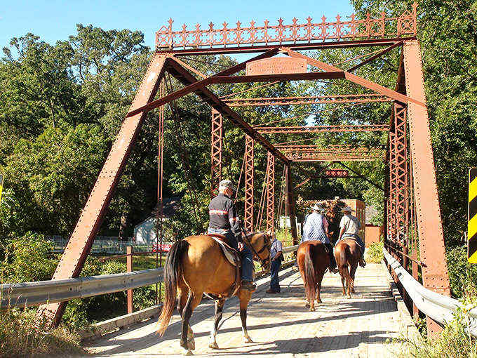 Horseback riders cross the historic bridge, experiencing transportation as nature intended &ndash; unpredictable and occasionally stubborn.