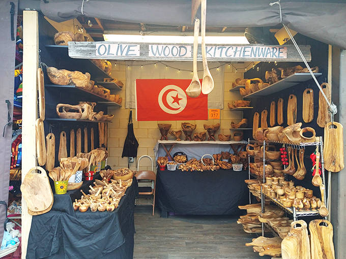 The Tunisian olive wood stand showcases handcrafted kitchen treasures, where every spoon and bowl carries the warmth of Mediterranean craftsmanship.