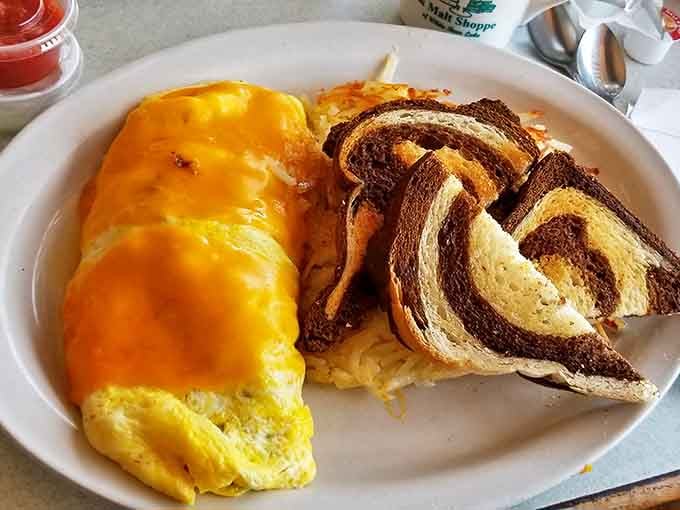A cheese omelet that's practically architectural in its perfection, paired with marble rye toast that's begging to be buttered.