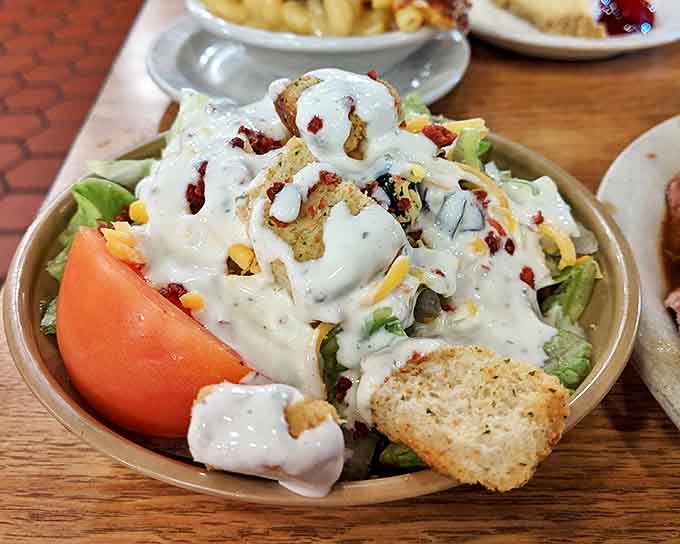 That salad is trying its best to look healthy under all that creamy dressing and crispy toppings, bless its heart for making the effort.