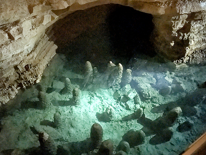 Underwater rock formations create an alien landscape beneath the surface, visible through water so clear it seems almost unreal.