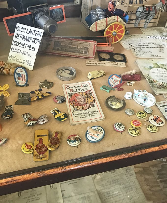 A German magic lantern from 1879 sits among Cracker Jack riddles and collectible pins – entertainment before screens captured our attention.