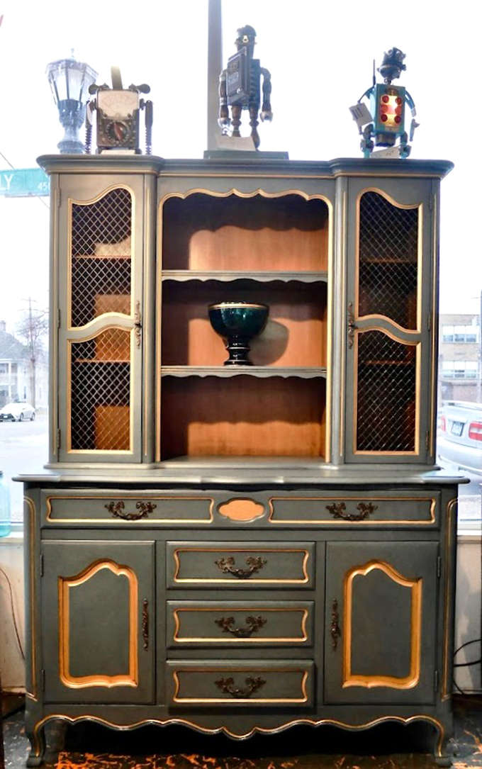 This elegant hutch cabinet stands like a dignified dowager at a punk rock concert, somehow perfectly at home among the eclectic surroundings.