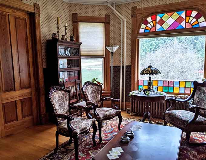 Stained glass catches afternoon light like jewels while Victorian chairs stand ready for genteel conversation. No Netflix needed when you've got this view.