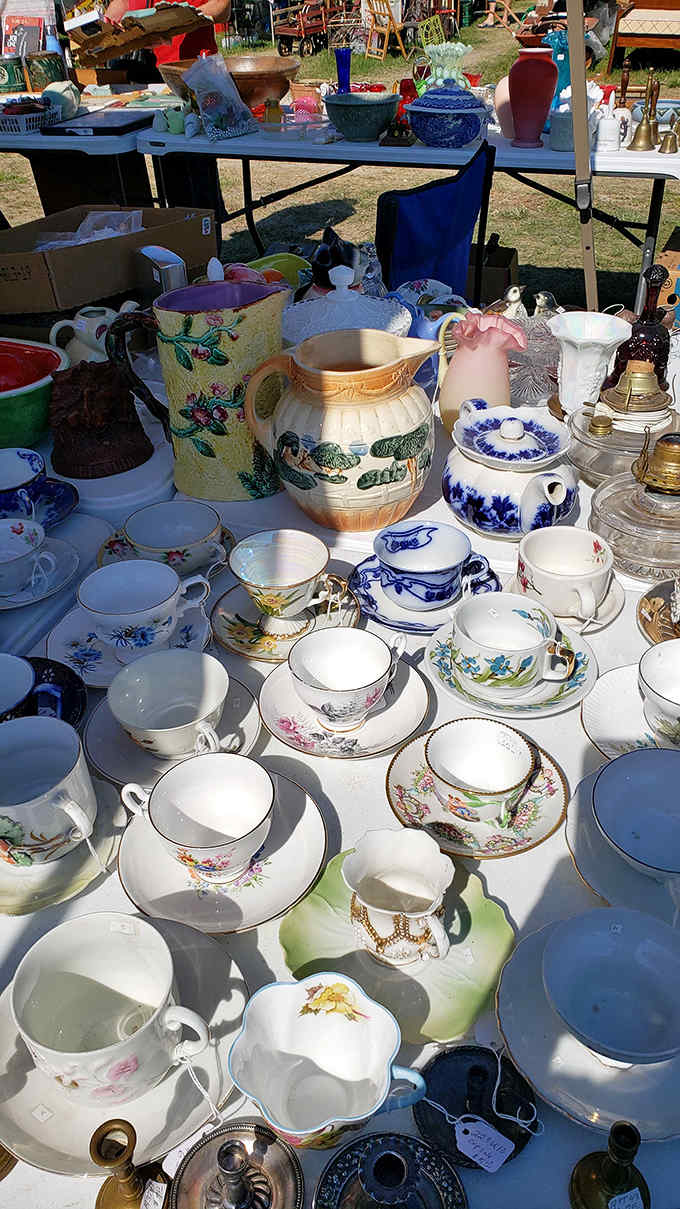 Delicate teacups arranged in perfect rows, their floral patterns and gold rims whispering of afternoon socials and proper etiquette.
