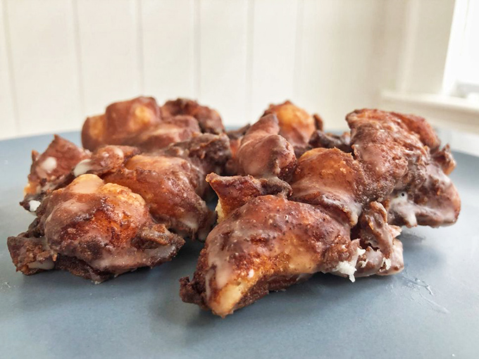 Not your average apple fritters &ndash; these golden beauties showcase caramelized chunks of real apple and a glaze that shatters perfectly with each bite.