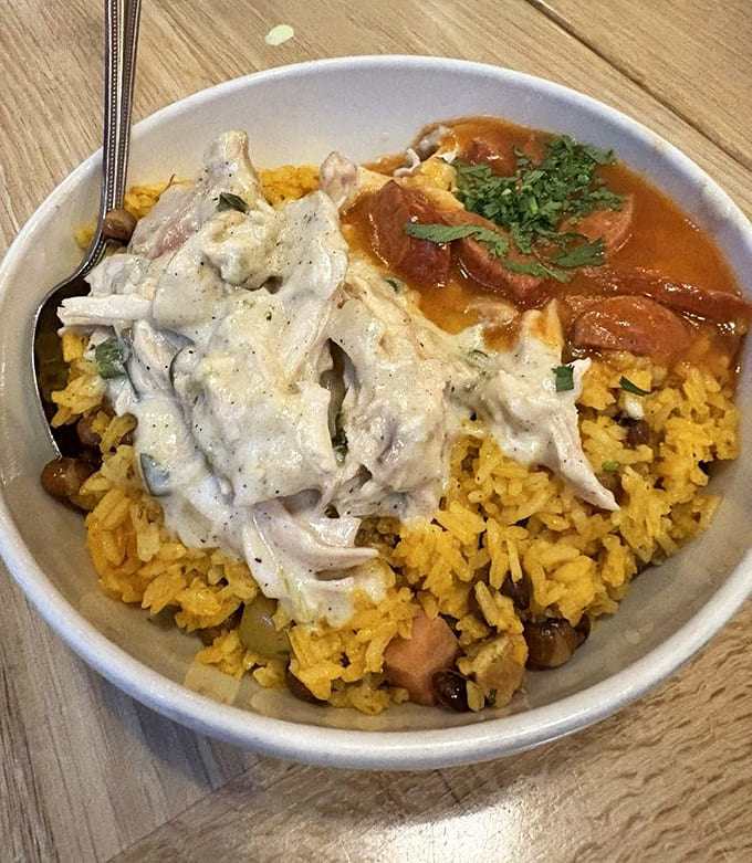 A colorful celebration in a bowl &ndash; tender chicken and vibrant rice sharing space with a sauce worth sopping up.