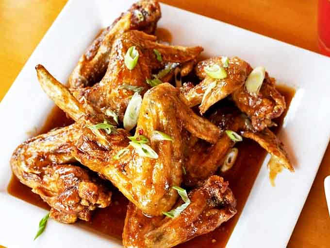 Asian Sesame Wings offer a flavor departure worth exploring &ndash; sweet, savory, and utterly craveable with delicate green onion garnish.