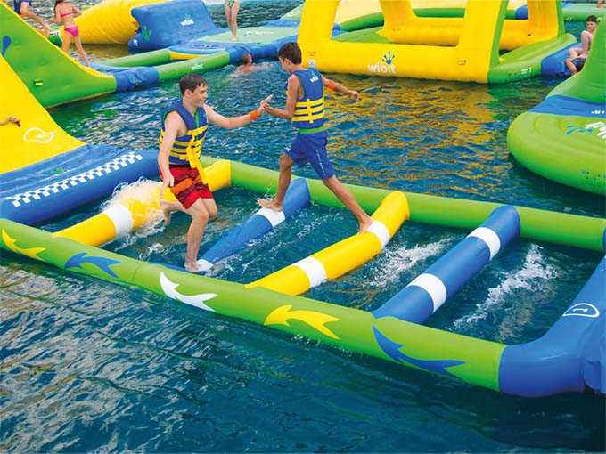 Two young adventurers navigate a wobbly bridge &ndash; demonstrating that childhood balance is superior to anything adults can muster after age 30.