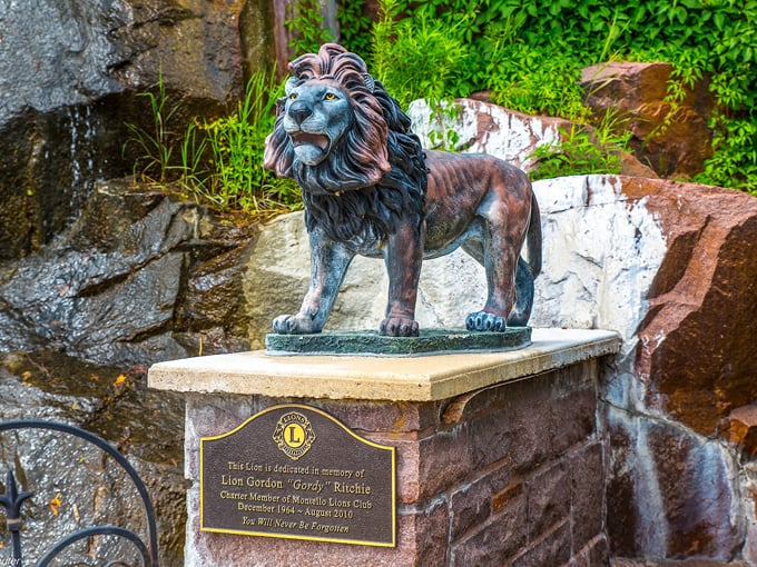 A bronze lion stands guard near the falls, commemorating community service while adding artistic flair to the natural setting.