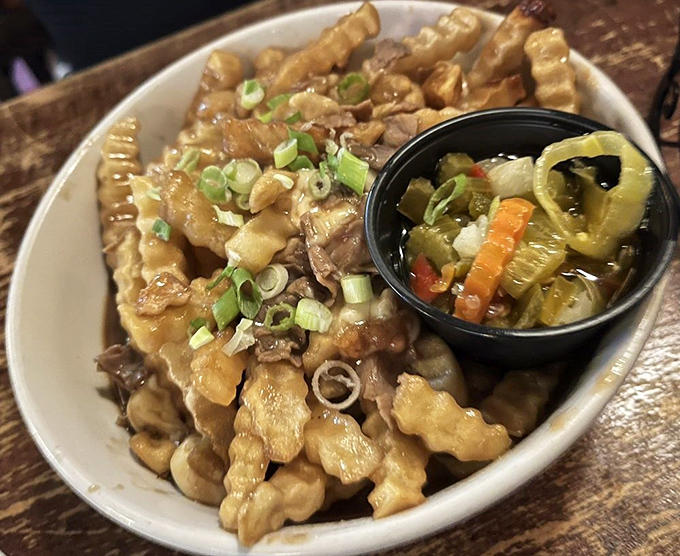 Gravy-smothered fries topped with green onions – a glorious mess that demands to be devoured before propriety can intervene.