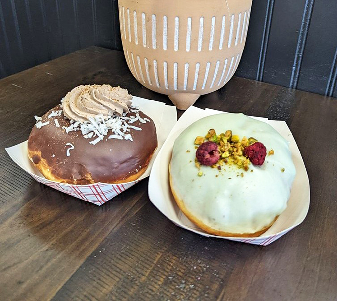 Two doughnuts that prove opposites attract: chocolate decadence meets pistachio elegance, both demanding equal attention from your taste buds.