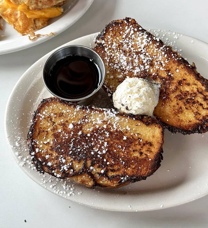 Golden-brown slices of bread that have achieved breakfast nirvana – crispy edges, custardy centers, and a dusting of powdered sugar like fresh snow.