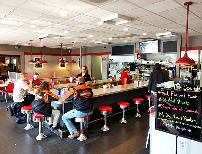 The counter scene: where regulars perch on red stools, trading stories while the specials board tempts with seasonal delights.