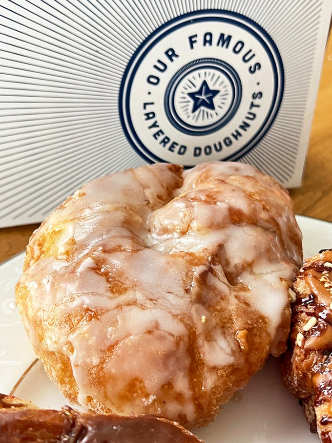 The Honey Glaze doughnut glistens with sweet promise &ndash; each layer visible beneath that crackling glaze like nature's perfect architecture.