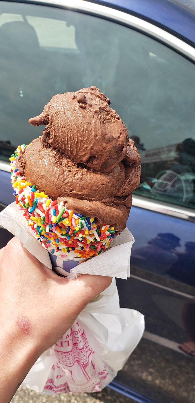 Ice cream that requires structural engineering skills to eat &ndash; notice the strategic sprinkle foundation supporting three scoops of chocolate heaven.