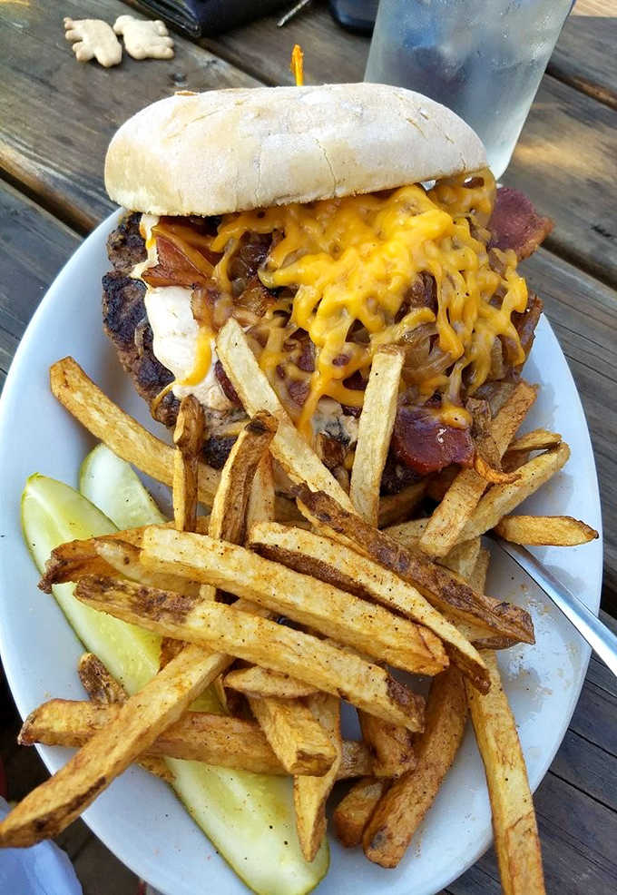 This towering creation features a golden crown of french fries atop layers of cheese, bacon, and beef &ndash; a burger wearing its own side dish.