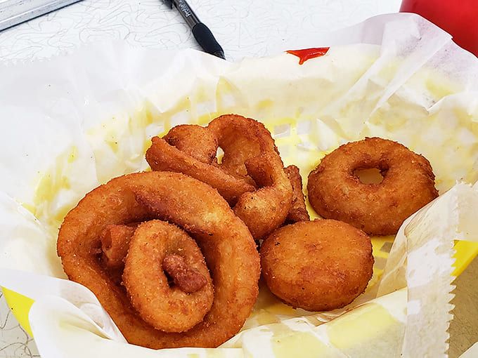 Golden, crispy onion rings that crunch like childhood memories &ndash; these circular treasures are worth the trip alone.