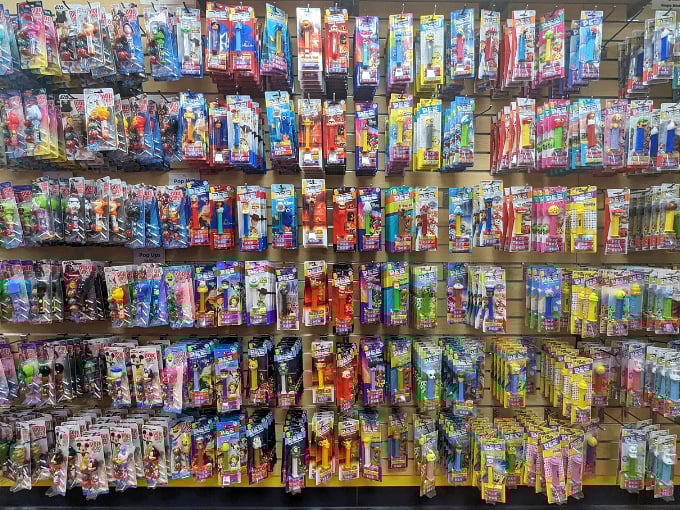 PEZ dispensers line up like a plastic army of pop culture history &ndash; tiny candy-dispensing time machines connecting generations through character heads and chalky treats.