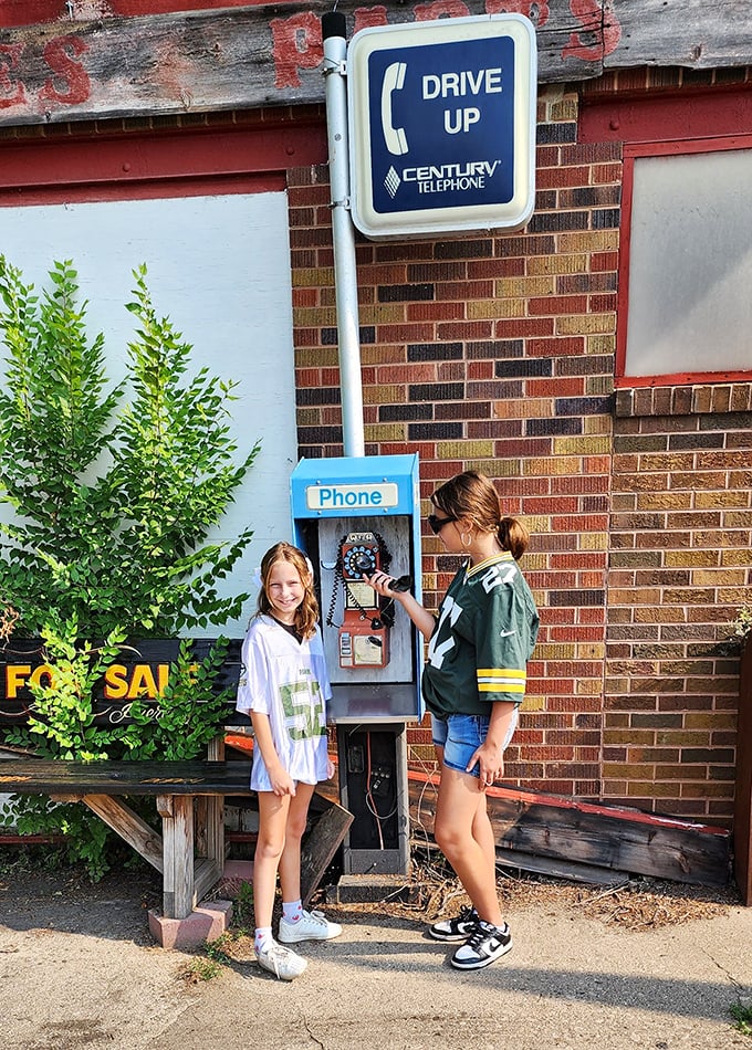 A vintage payphone stands ready for service, reminding younger visitors that people once actually had to stand still to make phone calls.