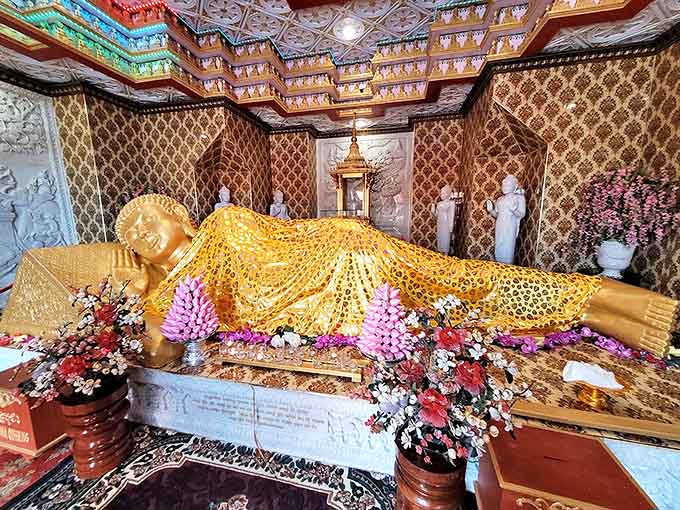 The reclining Buddha rests in golden splendor, draped in intricate cloth and surrounded by offerings &ndash; the ultimate power nap with cosmic significance.