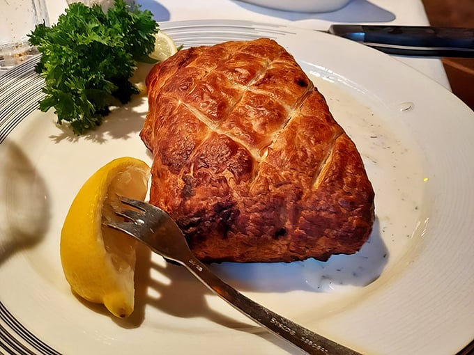 The Salmon Wellington offers a seafood twist on the classic, with perfectly cooked fish encased in golden pastry that shatters delicately with each bite.