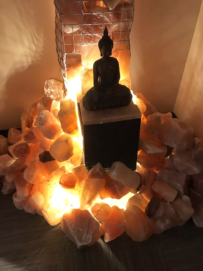 A meditation corner features illuminated salt crystals surrounding a Buddha statue, creating a focal point for mindfulness.