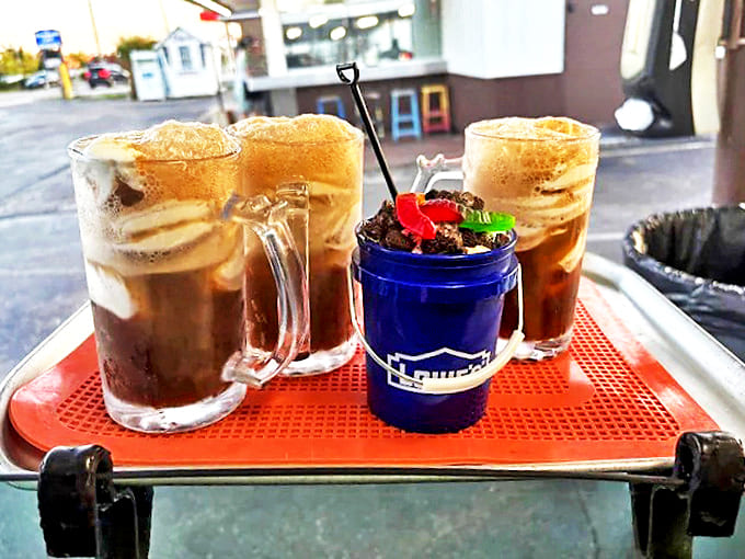 Root beer floats in proper glass mugs alongside dessert buckets &ndash; because sometimes happiness requires both fizz and a shovel-sized spoon.