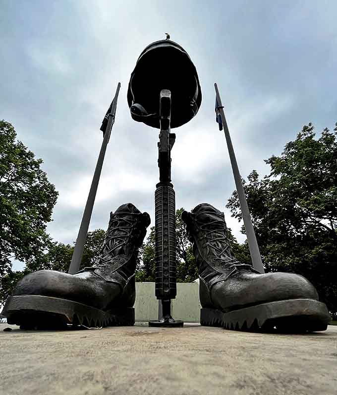The Veterans Memorial stands as a solemn tribute, boots and helmet silhouetted against Minnesota sky &ndash; a powerful reminder of sacrifice in steel and stone.
