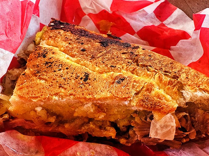 Look at those layers! The cross-section reveals the architectural perfection of properly pressed Cuban bread holding a treasure of fillings.
