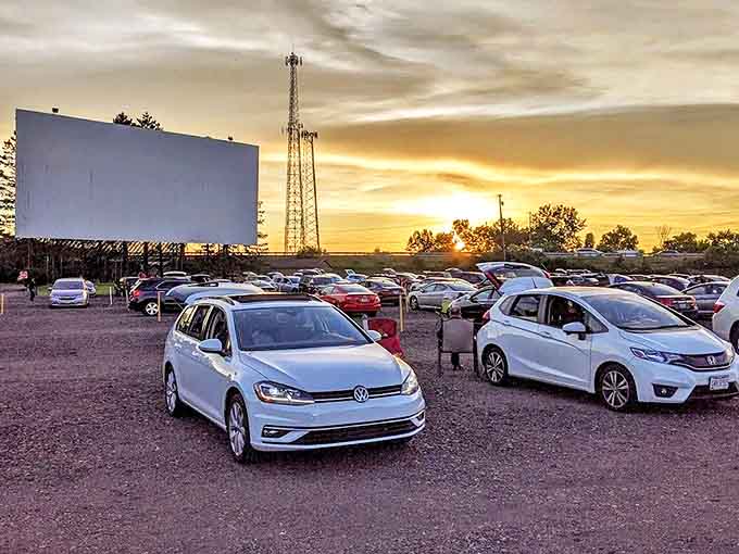 Vehicles arrange themselves in neat rows, each finding the perfect angle for an evening of outdoor cinema.