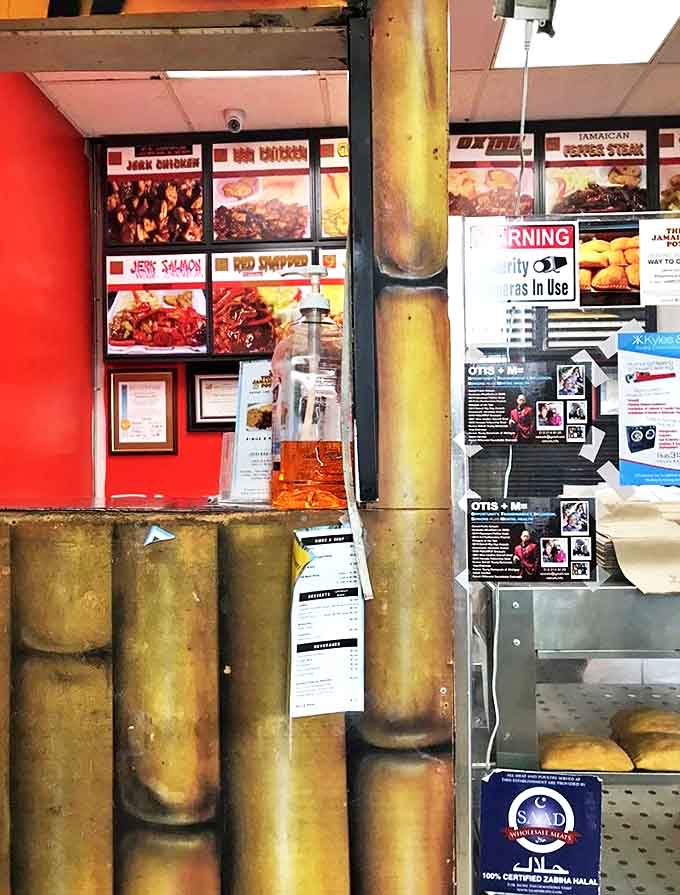 Behind bamboo accents, vibrant food photos showcase the restaurant's specialties, while the Jamaican flag proudly declares authentic island roots.