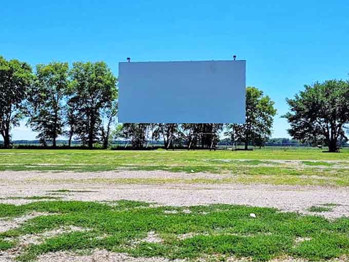 During daylight hours, the empty drive-in reveals its simple charm &ndash; just a screen and open space waiting to be transformed by nightfall.