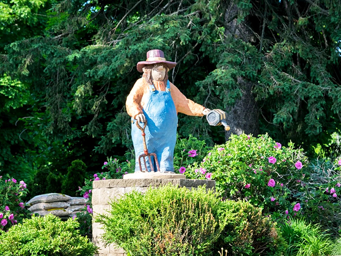 The farmer troll stands proudly among blooming flowers, watering can in hand, embodying the agricultural spirit that still thrives in Wisconsin.