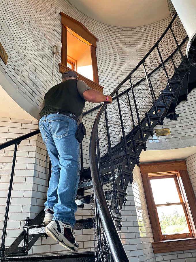 A visitor ascends the historic spiral staircase, each step a journey back in time. The craftsmanship of these iron stairs has withstood over a century of footsteps.