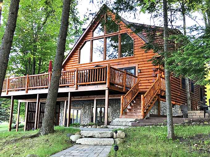 This log cabin's expansive deck offers panoramic lake views that make smartphone scrolling seem like the sad substitute it truly is.