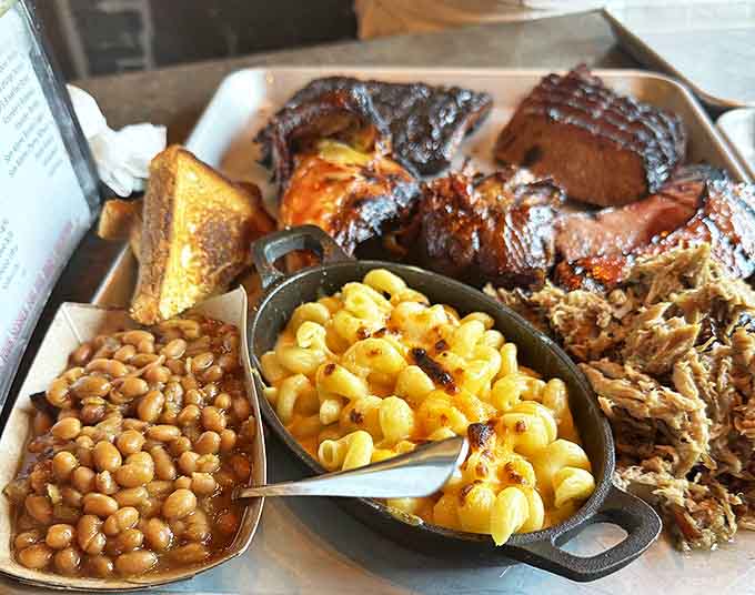 The holy trinity of barbecue sides: mac and cheese that bubbles with promise, beans swimming with flavor, and Texas toast for sopping duties.