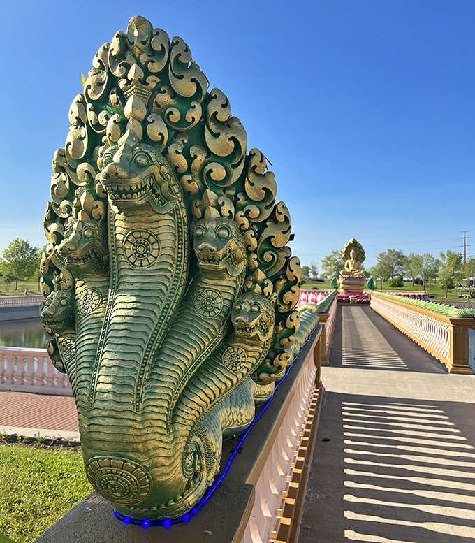 The multi-headed naga serpent deity guards the temple bridge with mythological majesty, its scales gleaming under the Midwestern sun.