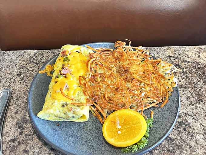 A perfectly executed omelet alongside crispy hash browns proves that sometimes the simplest dishes require the most skill to perfect.